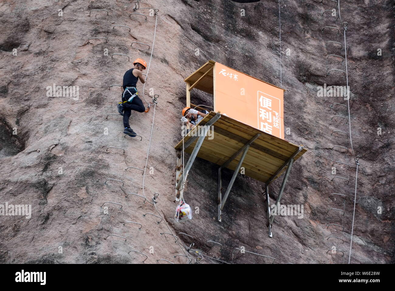 A tourist who practices rock climbing buys a bottle of water from the ...