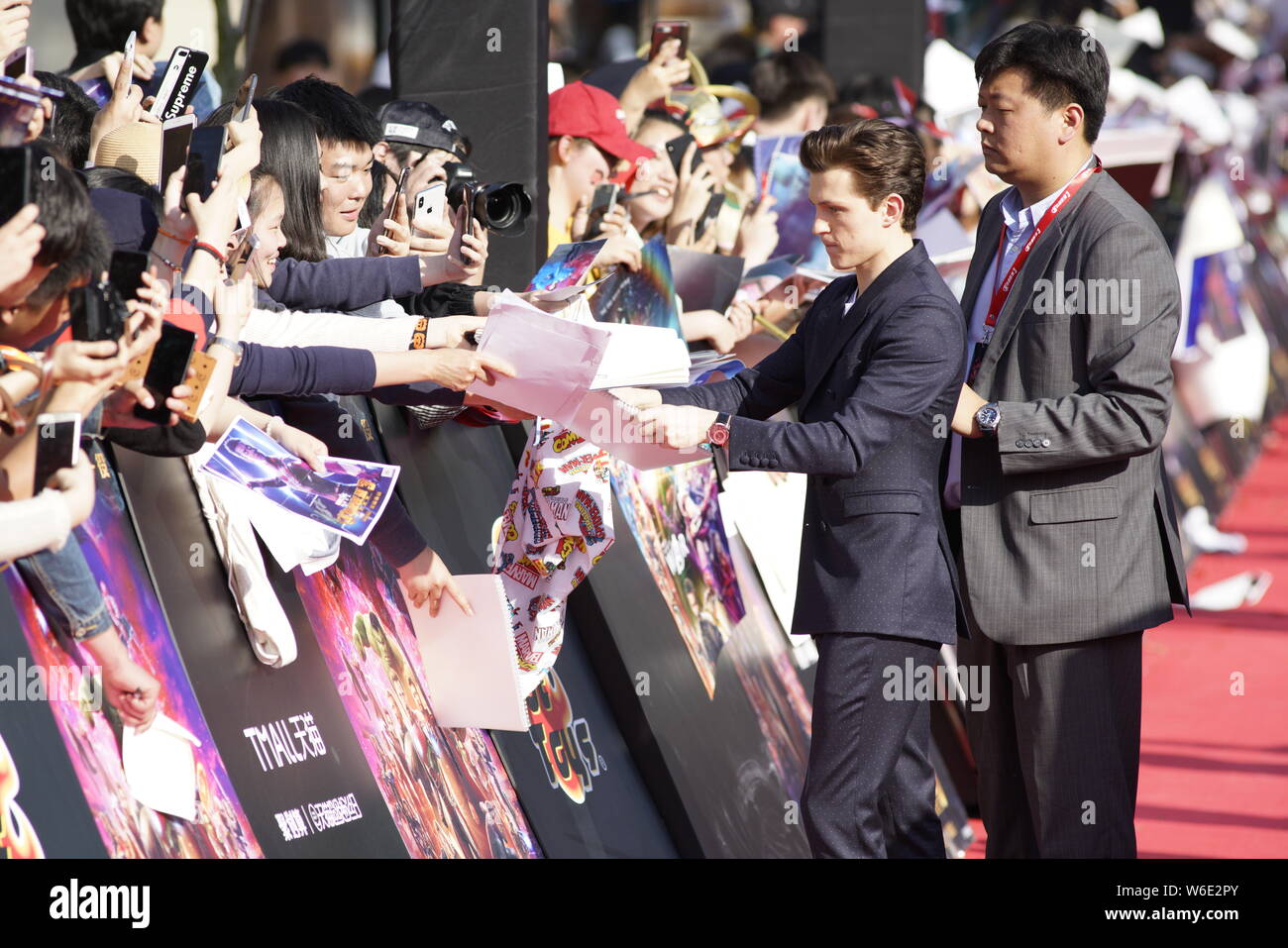 English actor Tom Holland signs autographs for fans as he arrives on ...