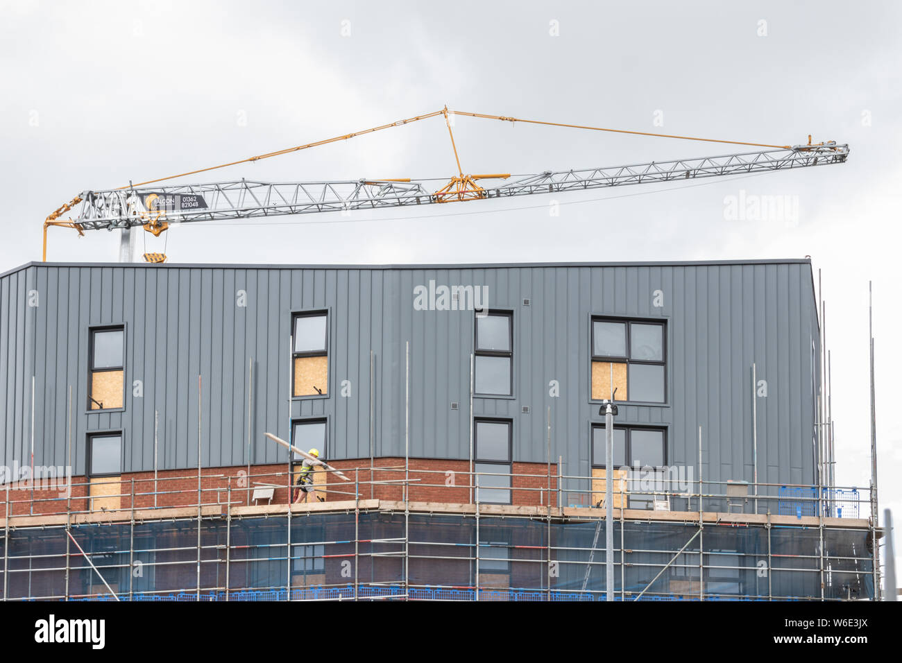 A tower block under construction with builders or construction workers ...