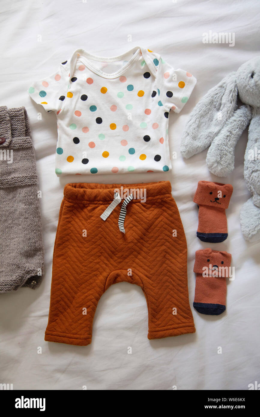 A cute baby outfit layed out on a white sheet background Stock Photo ...