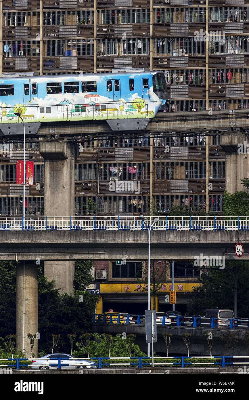 A monorail train of Chongqing Light Rail runs through high-rise ...