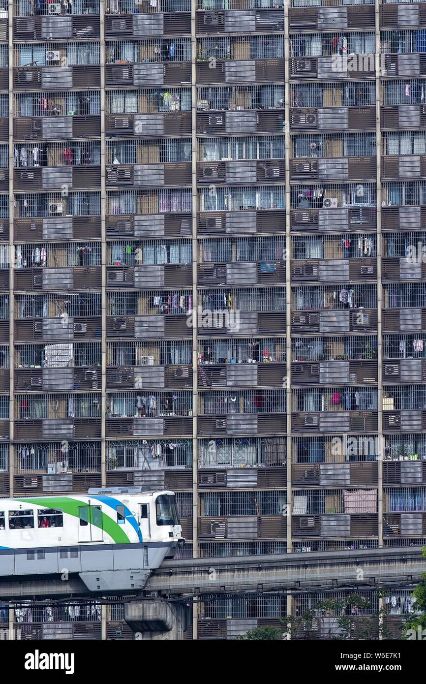 A monorail train of Chongqing Light Rail runs through high-rise ...