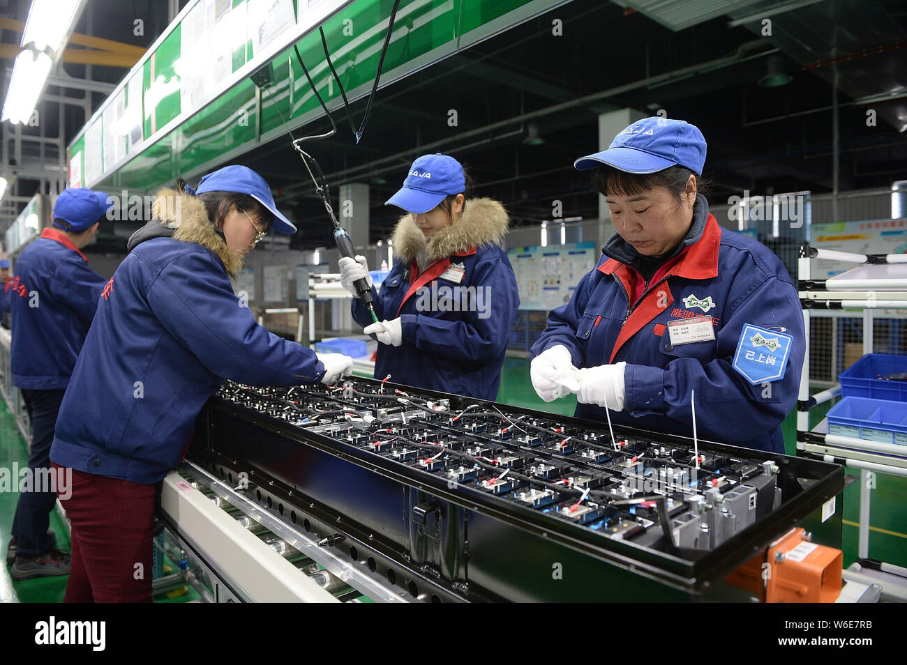 Chinese workers produce batteries at a factory in Chengdu city ...
