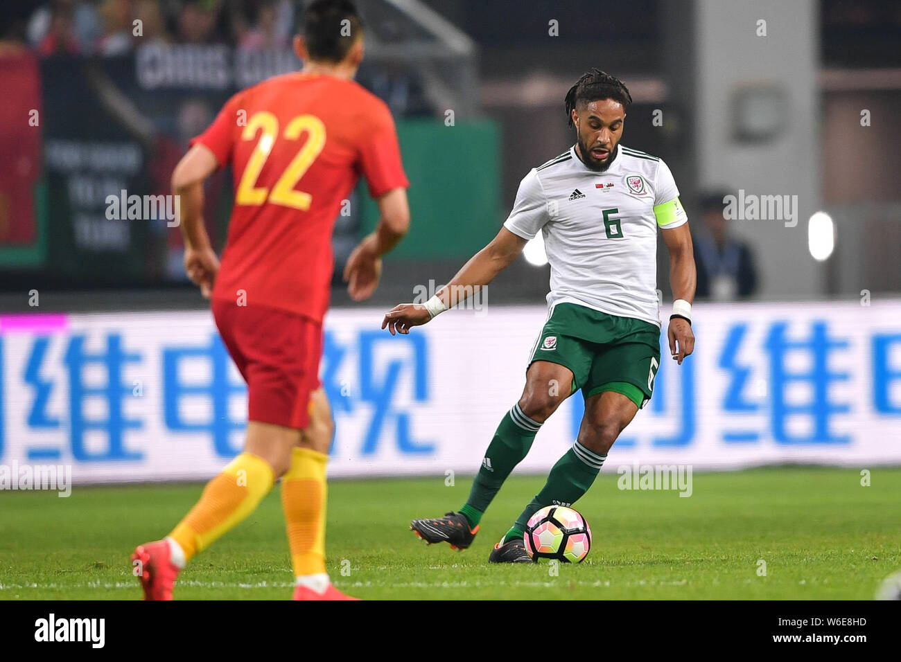 Ashley Williams, right, of Wales national football team kicks the ball ...