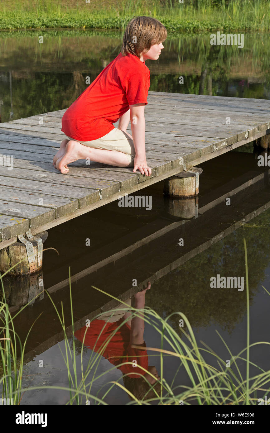 boy kneeling on a landing stage, Bayerisch Eisenstein, Bayerischer Wald ...