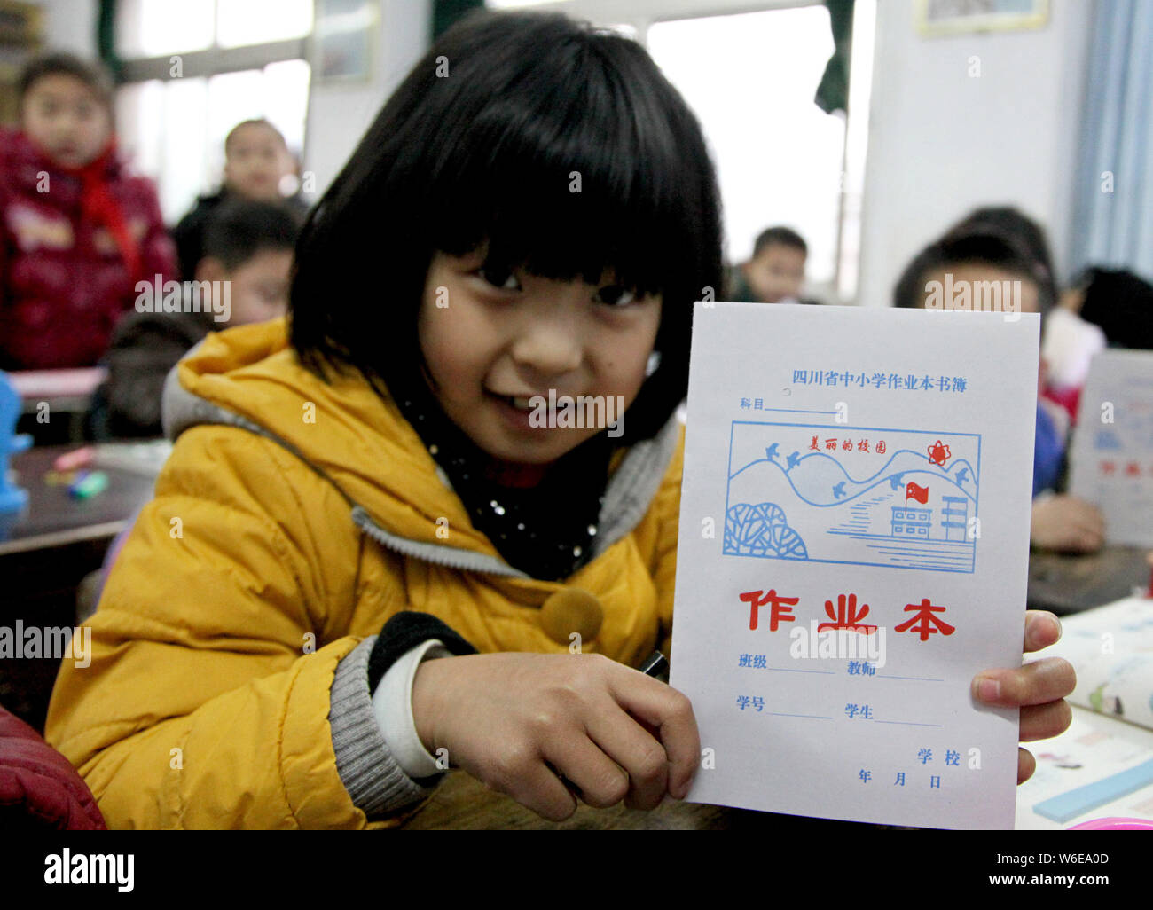 --FILE--A pupil shows her homework book at a primary school in Huaying ...