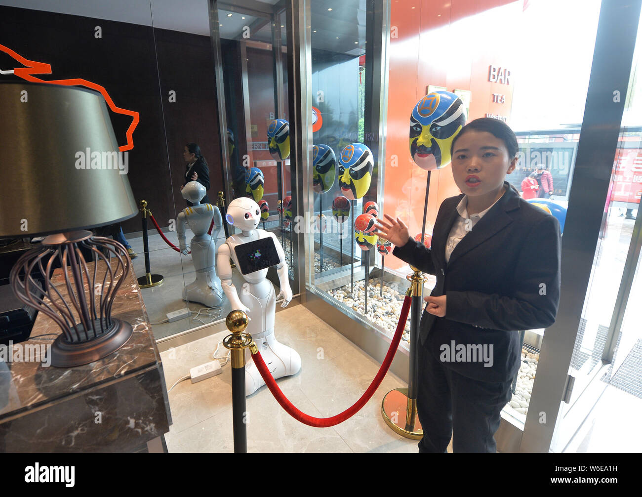 A Chinese employee introduces an intelligent robot at a high tech hotel ...