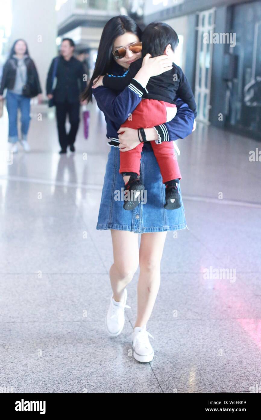 Taiwanese actress Michelle Chen carries her son at the Beijing Capital ...