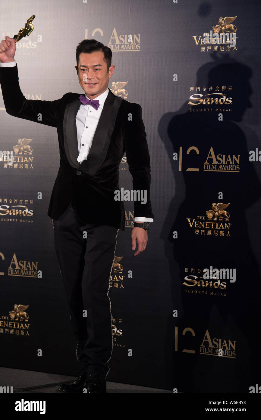 Hong Kong singer and actor Louis Koo holds up his trophy after winning ...