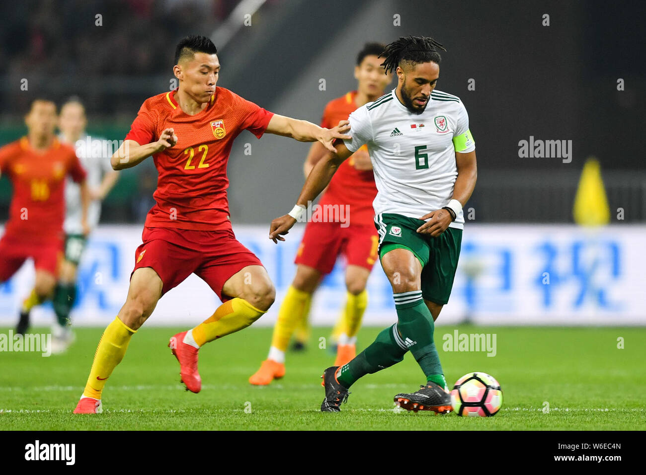Ashley Williams, right, of Wales national football team kicks the ball ...