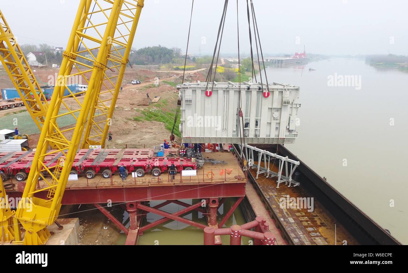 A crane vehicle lifts the world's most powerful converter transformer ...