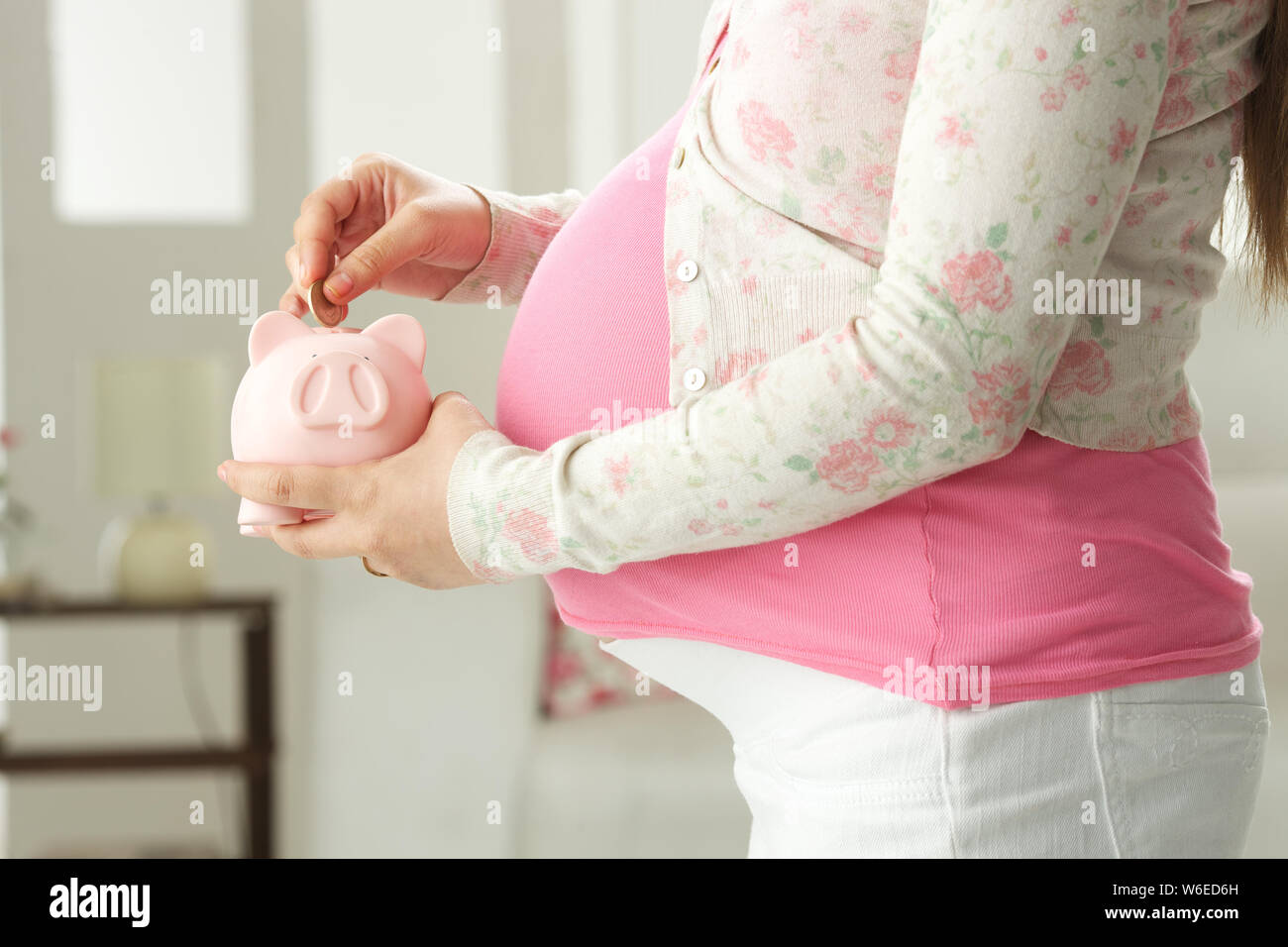 Woman hand inserting coin piggy hi-res stock photography and images - Alamy