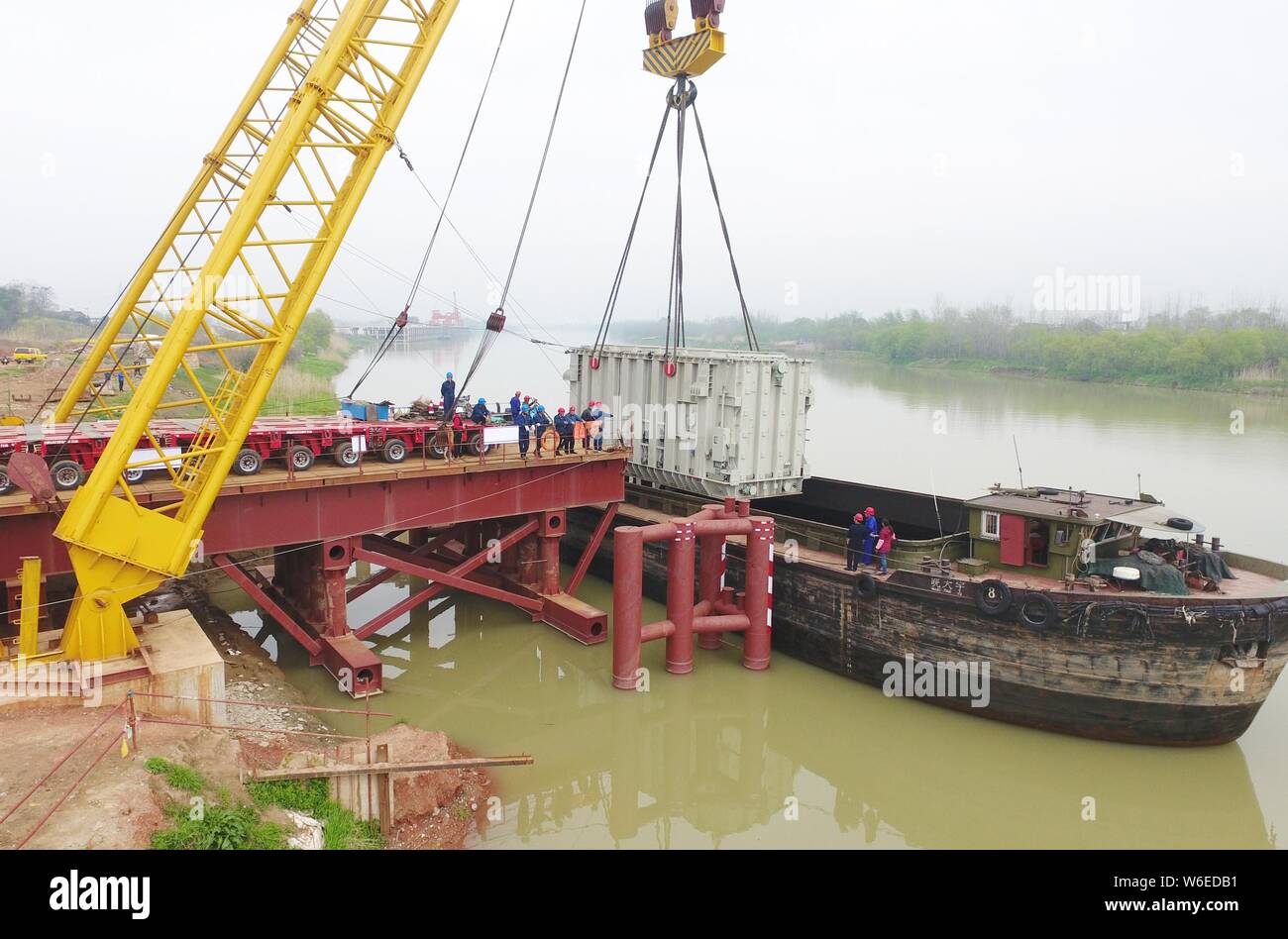 A crane vehicle lifts the world's most powerful converter transformer ...