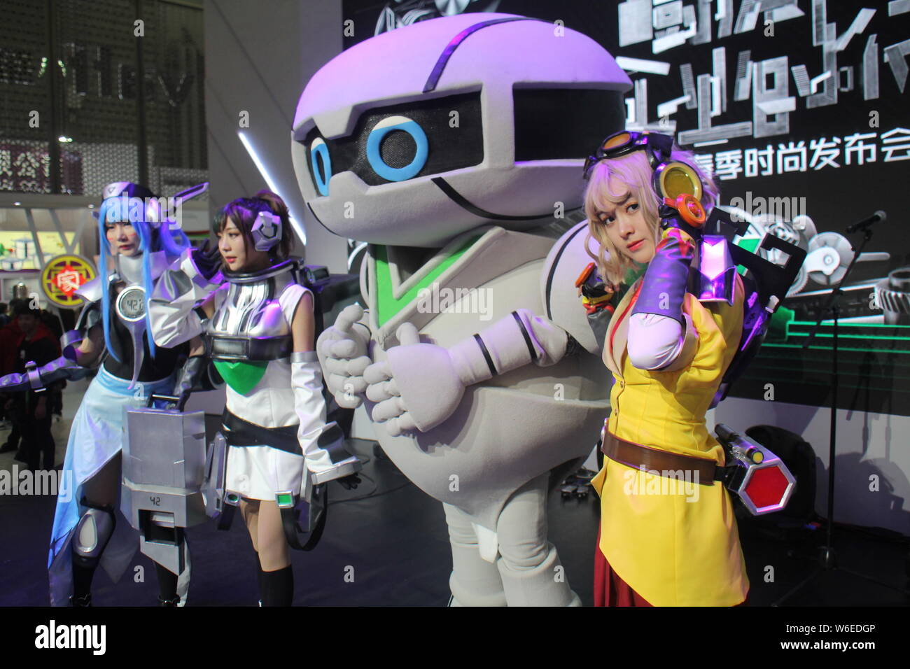 Female cosplayers take photos with an AI robot during the Appliance ...