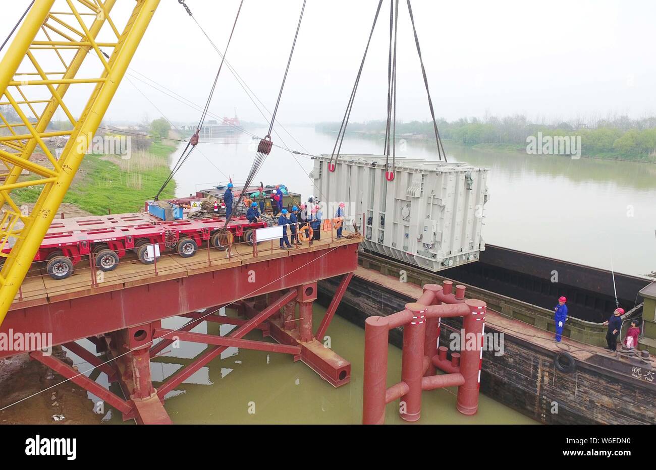 A crane vehicle lifts the world's most powerful converter transformer ...