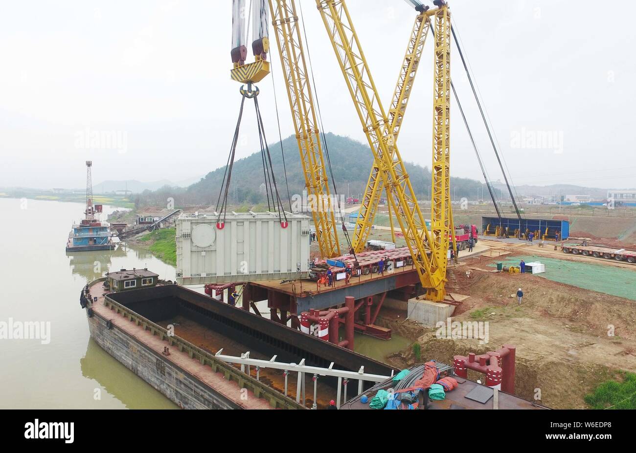 A crane vehicle lifts the world's most powerful converter transformer ...