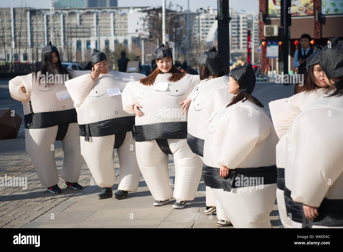 Chinese women dressed in inflatable sumo-wrestler costumes take part in ...