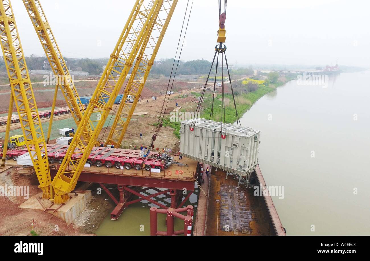A crane vehicle lifts the world's most powerful converter transformer ...