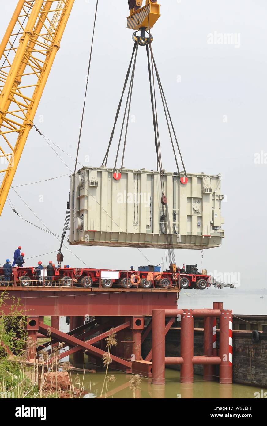 A crane vehicle lifts the world's most powerful converter transformer ...