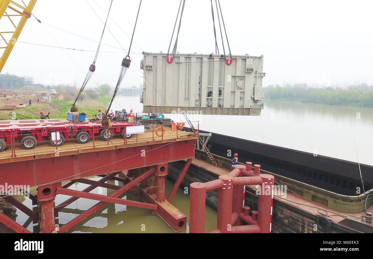 A crane vehicle lifts the world's most powerful converter transformer ...