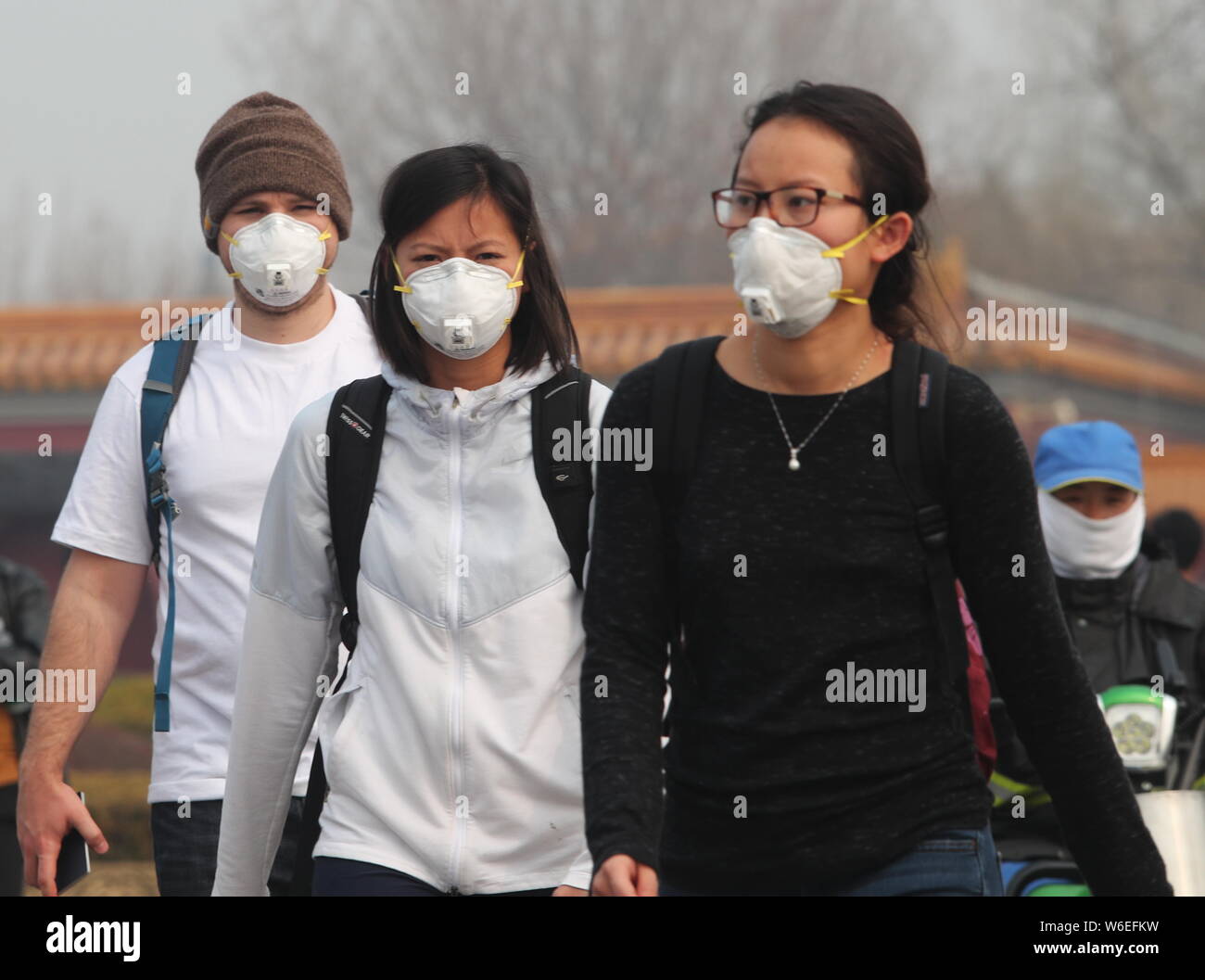 --FILE--Tourists wearing face masks against air pollution visit the ...