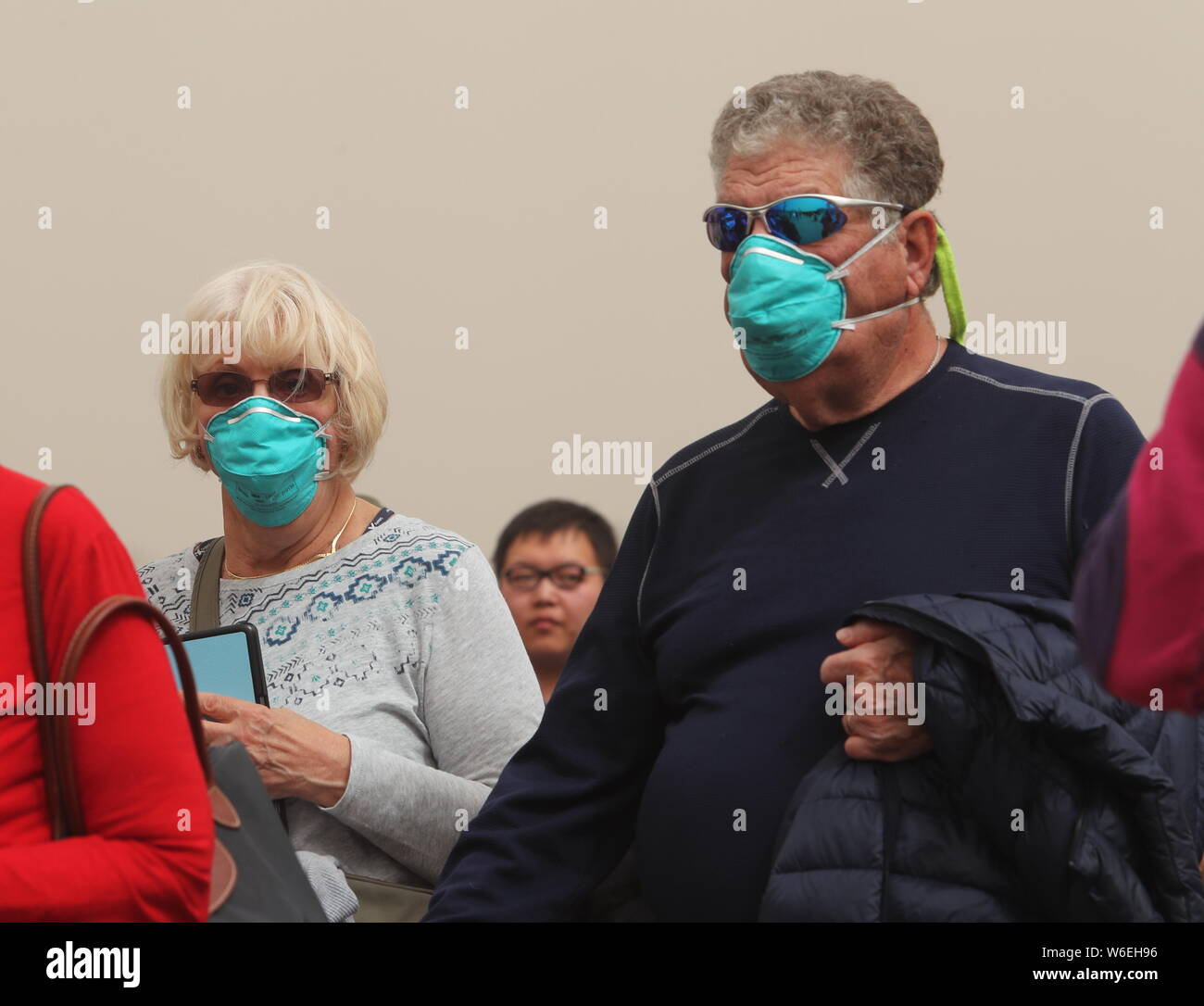 Foreign tourists wearing face masks against air pollution visit the ...