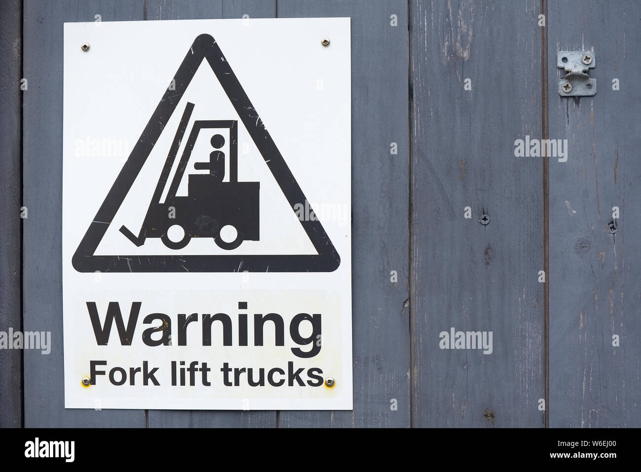 Old Warning Fork lift trucks sign black text and symbol in a triangle ...