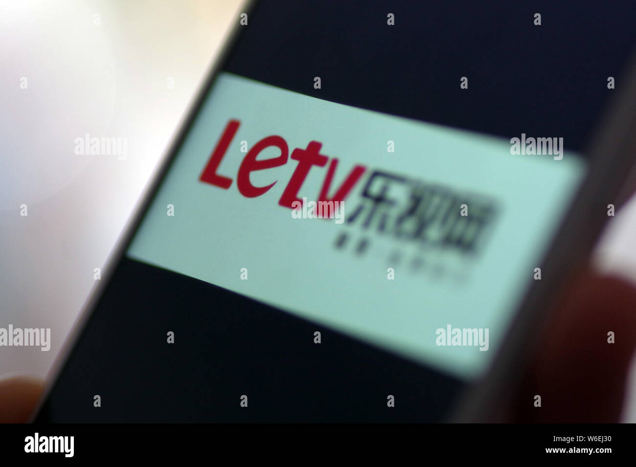 --FILE--A mobile phone user uses the mobile app of Leshi or Letv, on his smartphone in Ji'nan ...