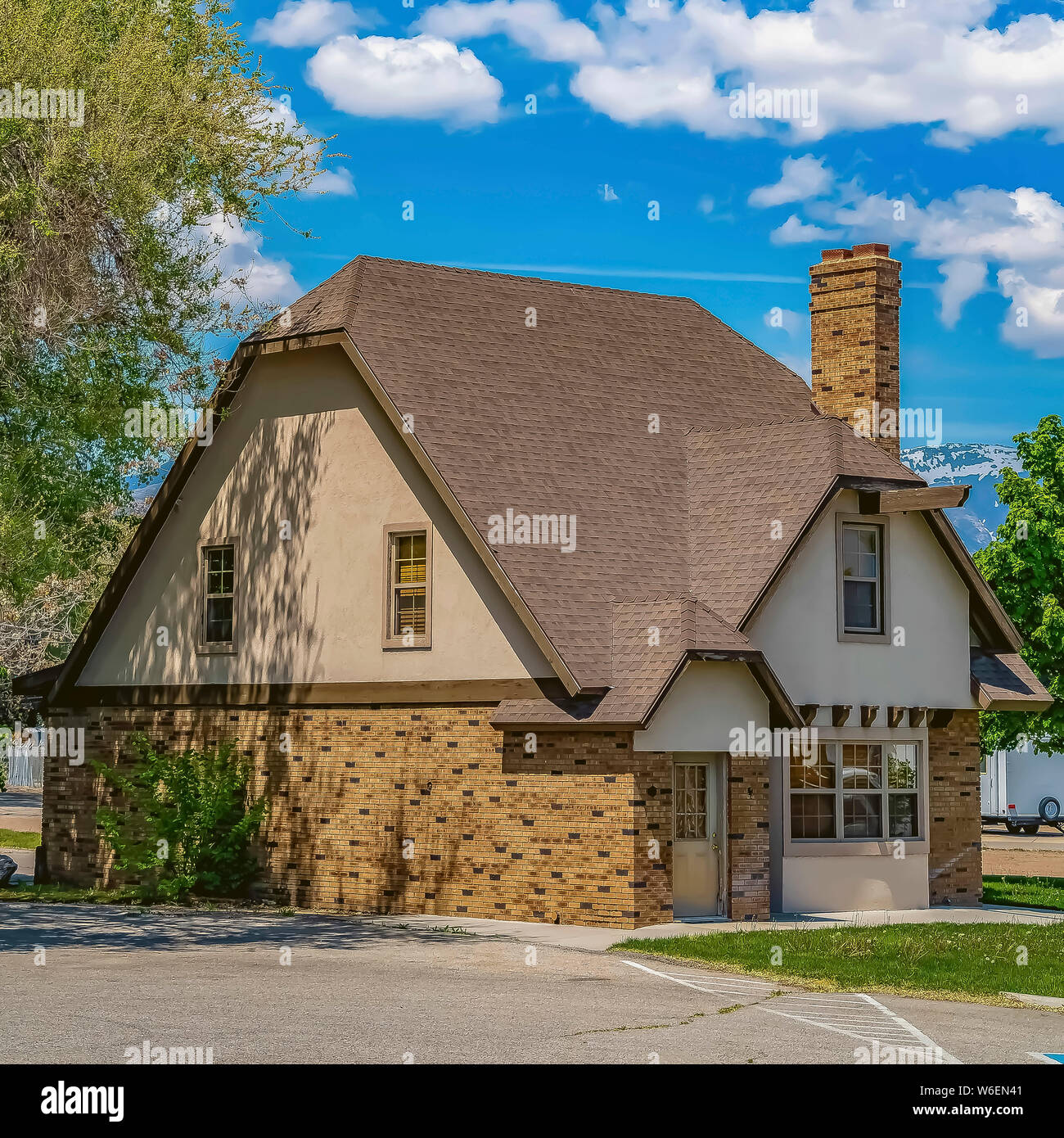 Square frame Exterior of a home with brick wall dark roof shiny windows ...