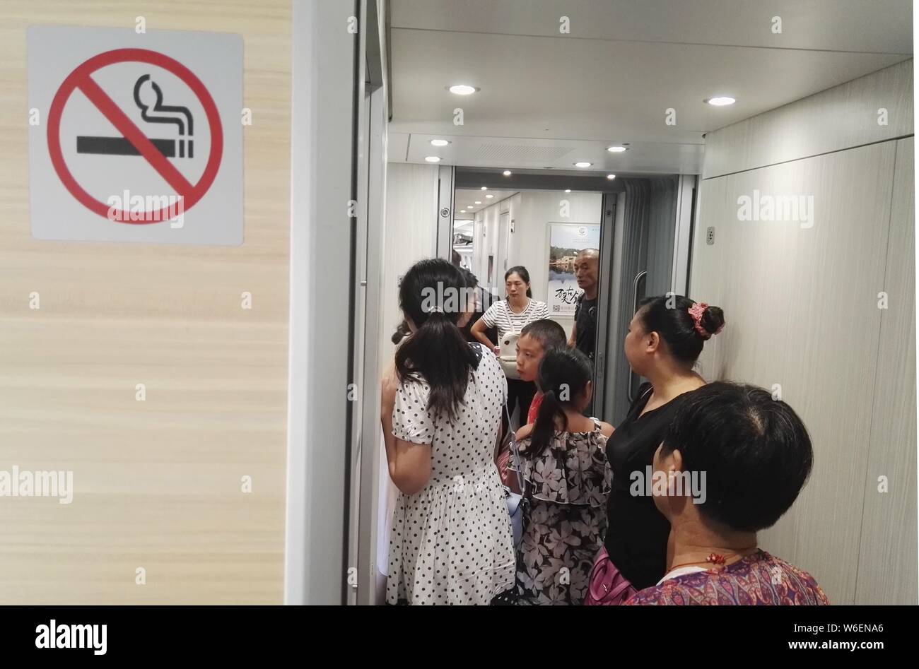--FILE--Passengers are pictured beside a No Smoking sign on a bullet ...