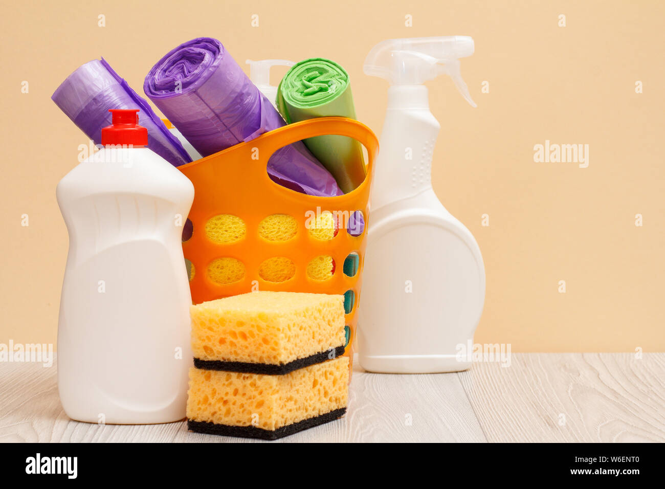 Plastic bottles of glass and tile cleaner, basket with garbage bags ...