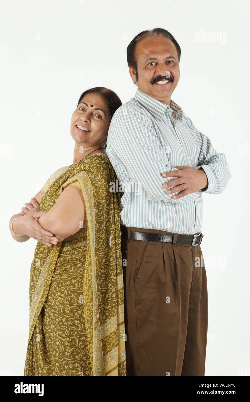 Old couple standing back to back and smiling Stock Photo - Alamy