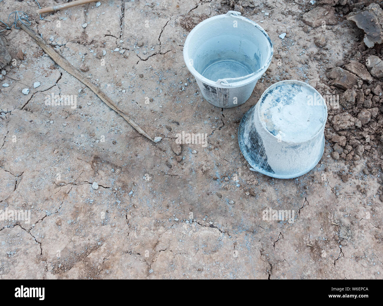Twin plastic bucket with the cement stain on the ground of the ...