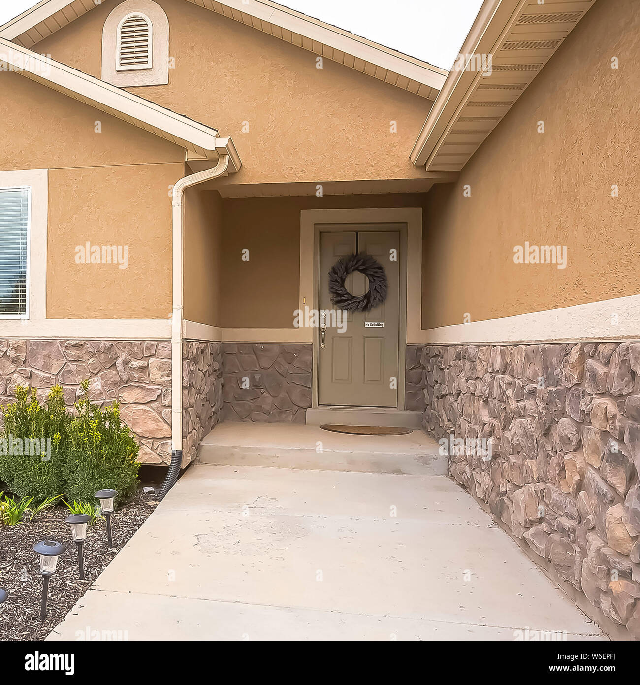 Square Pathway lined with bollard lights and leading to the front door ...