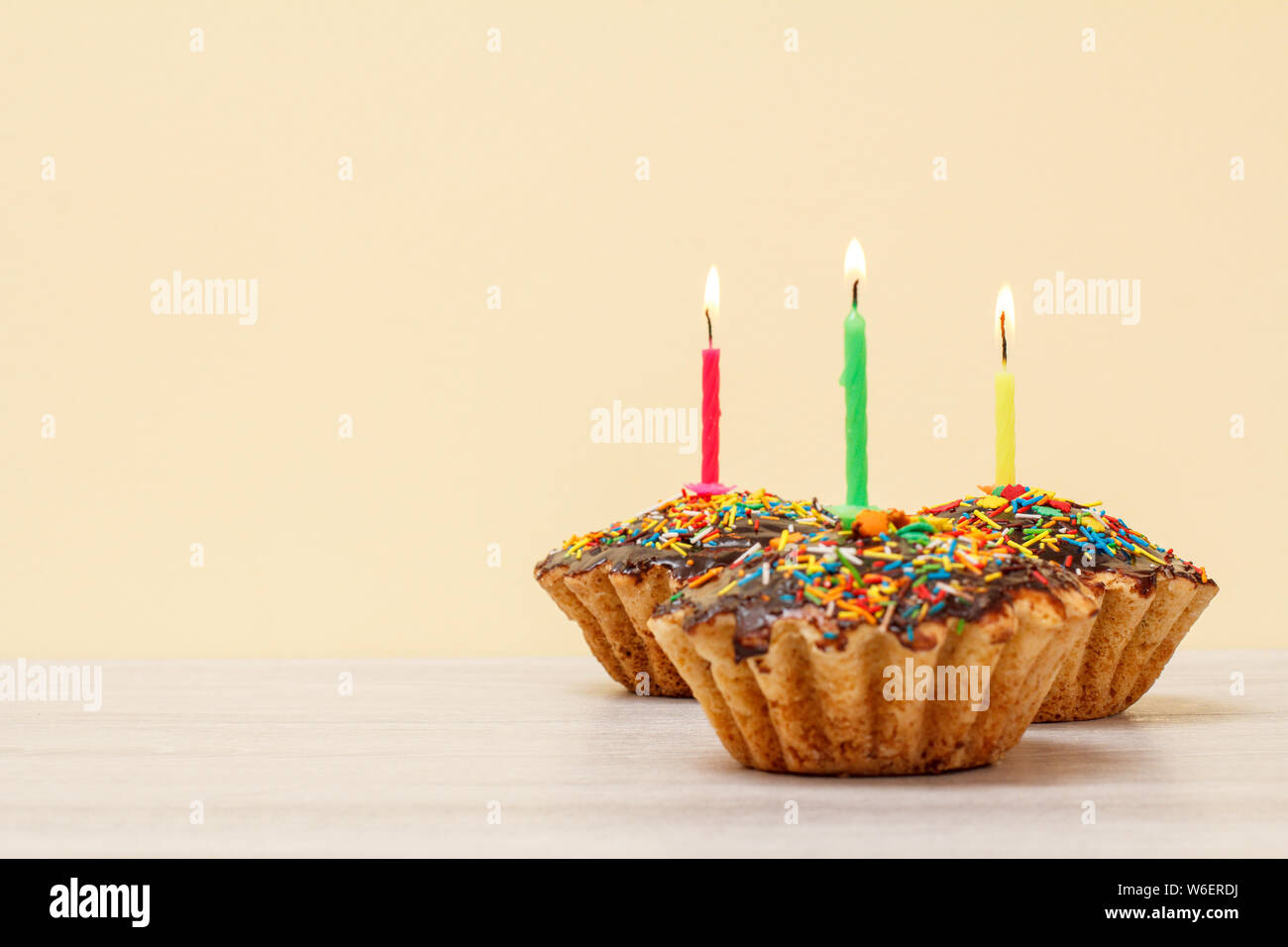 Tasty birthday muffins with chocolate glaze and caramel, decorated with ...