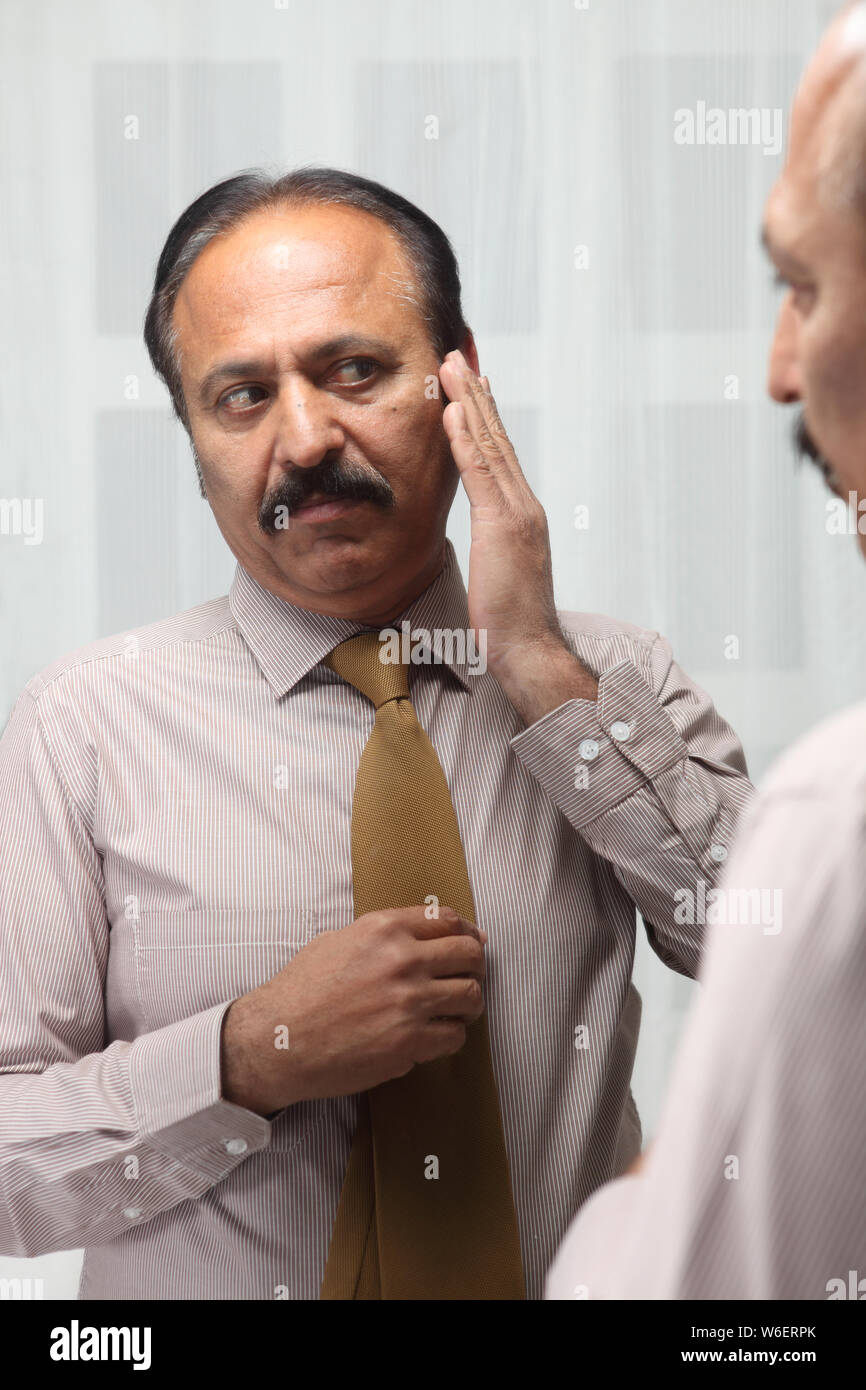 Mature businessman getting dressed in hi-res stock photography and ...