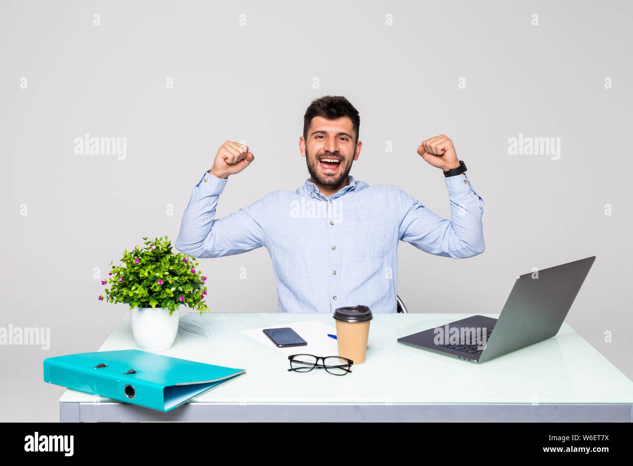 Happy young man in formal wear looking at computer monitor and ...