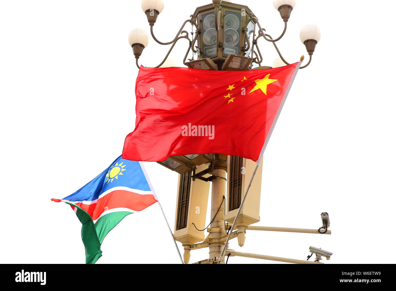 Chinese and Namibian national flags flutter on a lamppost in front of ...