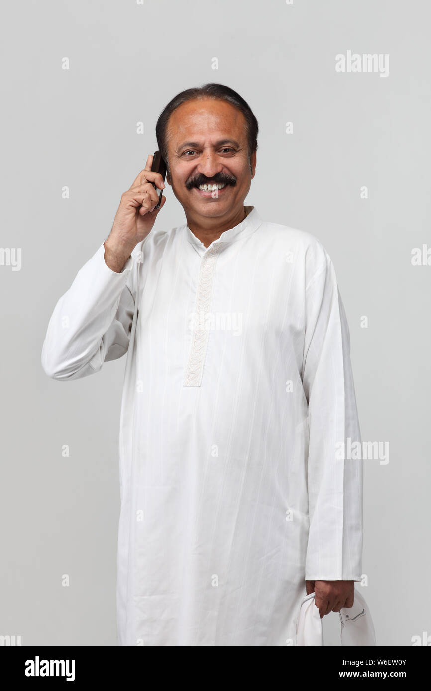 Bengali man talking on a mobile phone and smiling Stock Photo - Alamy