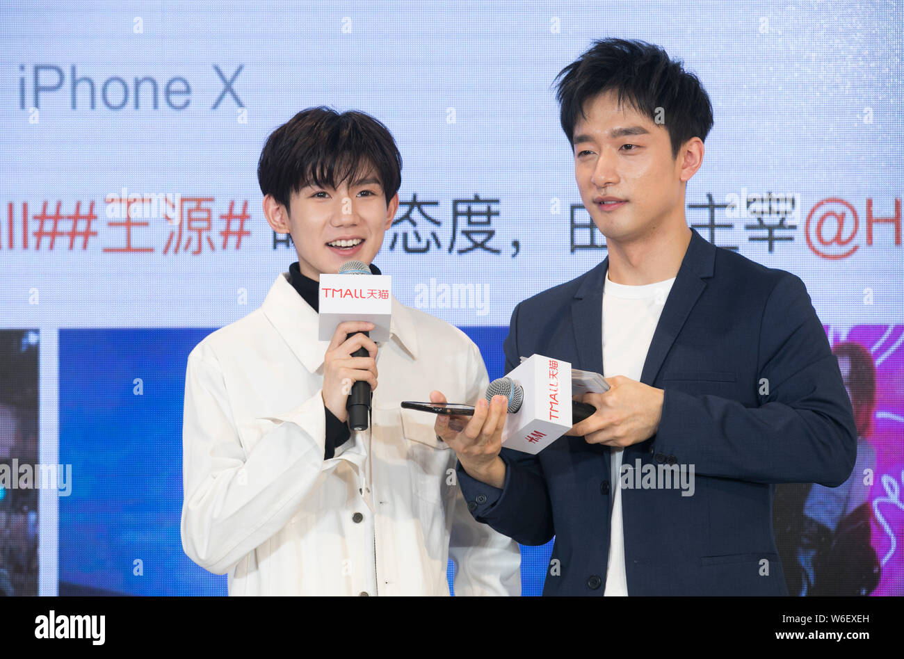 Roy Wang or Wang Yuan, left, of Chinese boy group TFBoys attends the launch ceremony for fashion ...