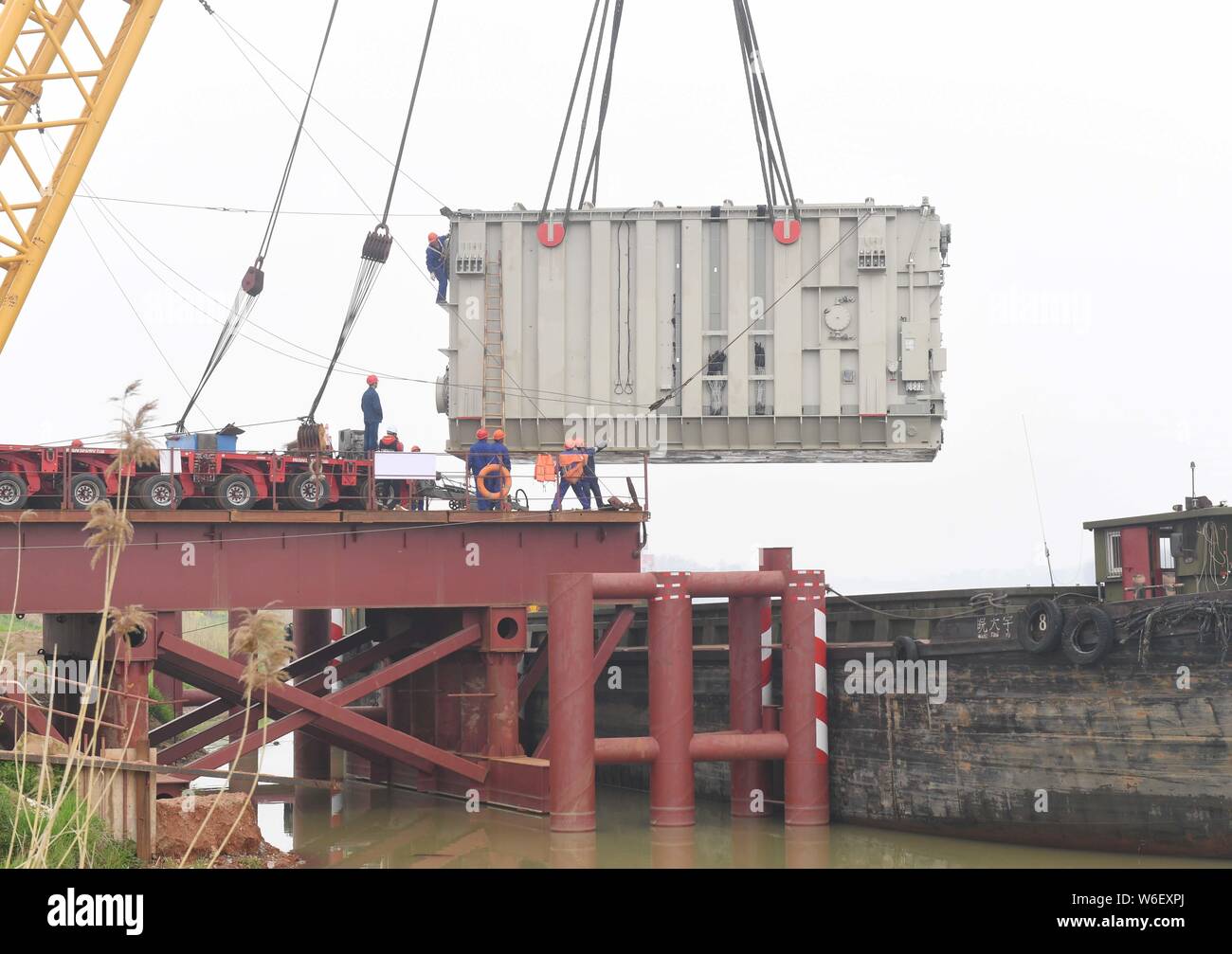 A crane vehicle lifts the world's most powerful converter transformer ...