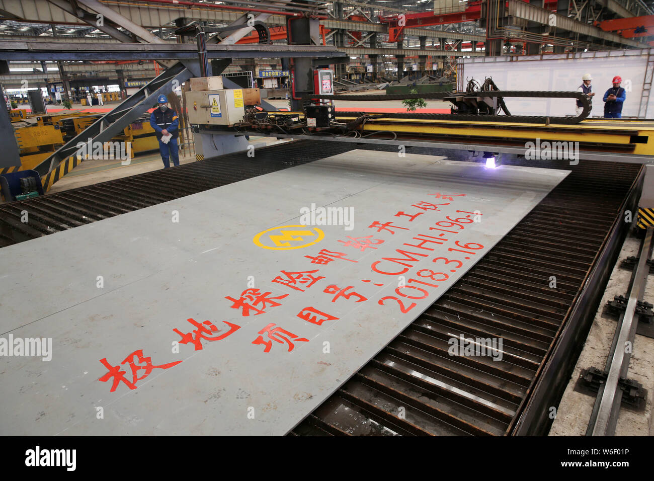 Technicians cut a steel plate during the launch ceremony for the ...