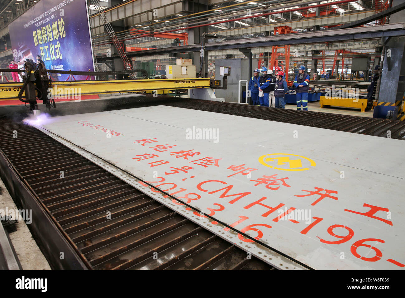 Technicians cut a steel plate during the launch ceremony for the ...