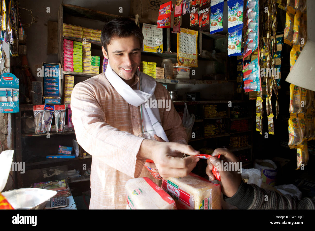 Shopkeeper giving toffee to customer Stock Photo - Alamy