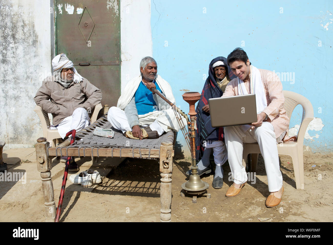 Man explaining to villagers with a laptop Stock Photo - Alamy