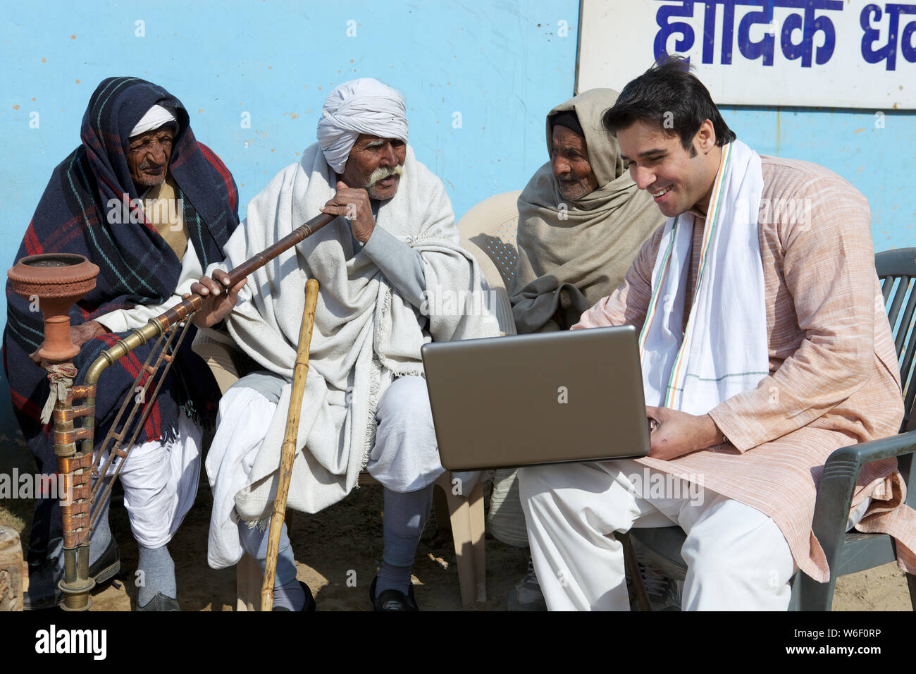 Man explaining to villagers with a laptop Stock Photo - Alamy