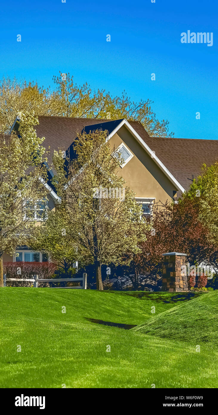 Vertical frame Facade of house on the vast grassy terrain under clear ...