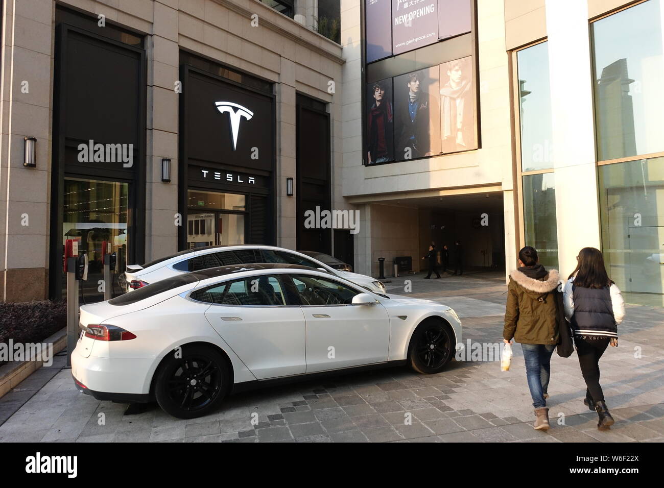 --FILE--Pedestrians walk past a dealership store of Tesla in Shanghai ...