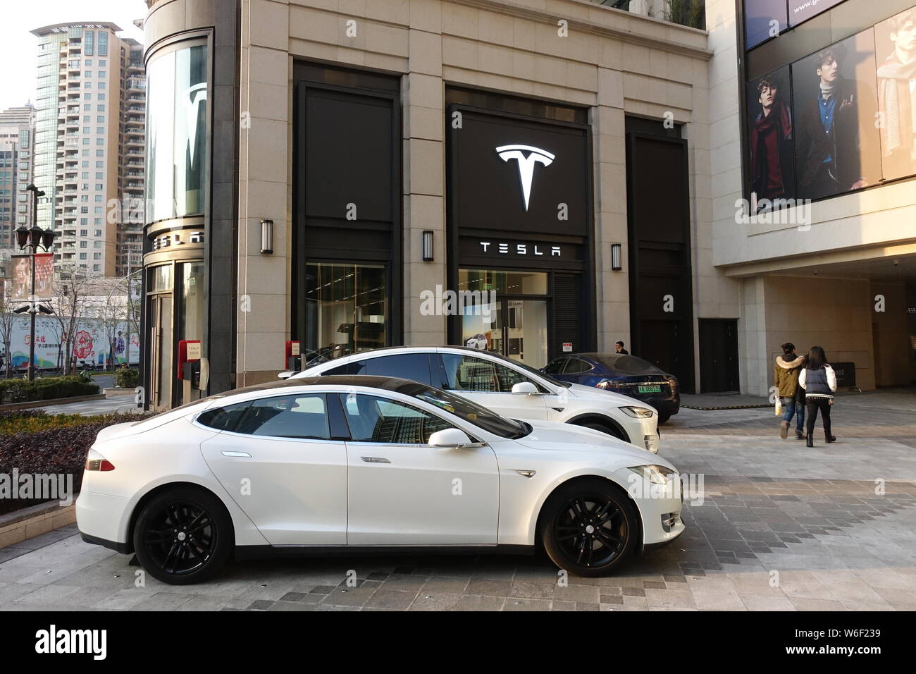--FILE--Pedestrians walk past a dealership store of Tesla in Shanghai ...