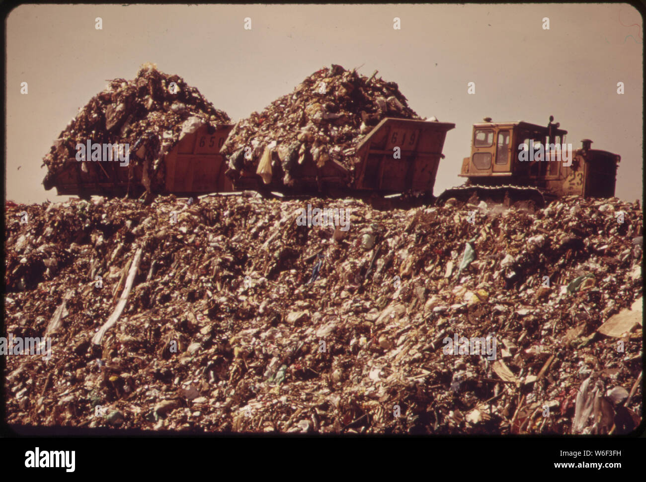AT STATEN ISLAND LANDFILL. CARTS HEAPED WITH GARBAGE BROUGHT BY BARGE ...